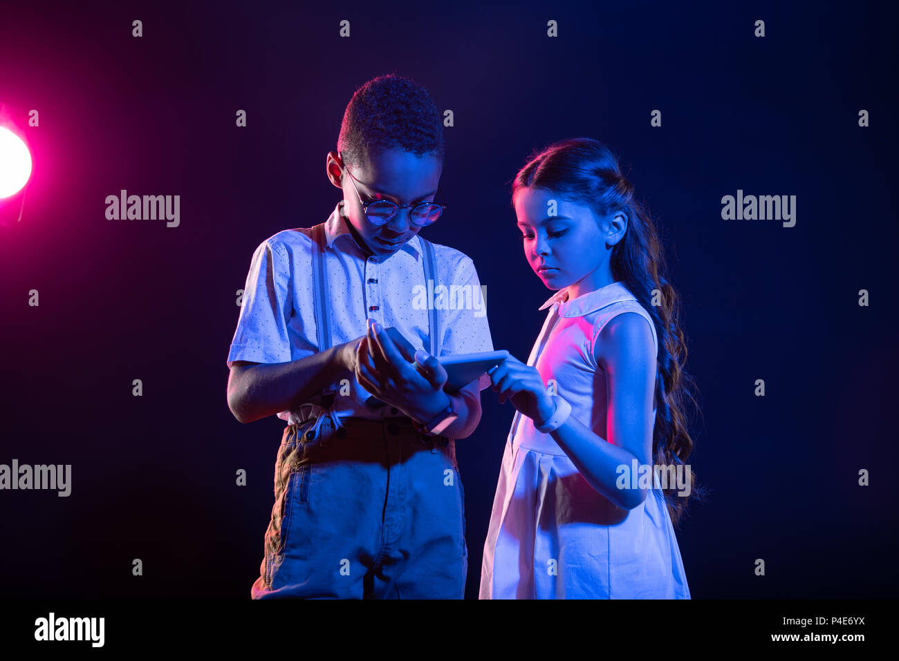 Serious children looking at the tablet Stock Photo - Alamy