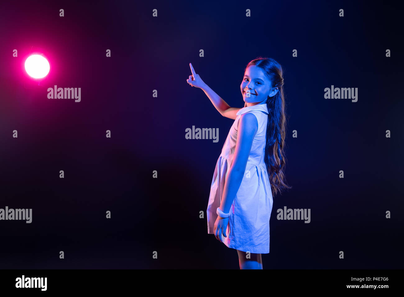 Joyful little girl pressing imaginary buttons Stock Photo - Alamy