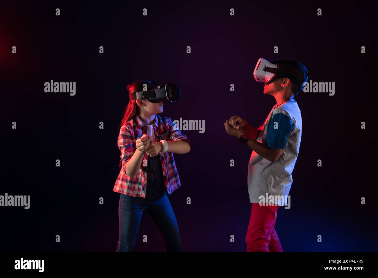 Concentrated little kids wearing VR headsets Stock Photo - Alamy
