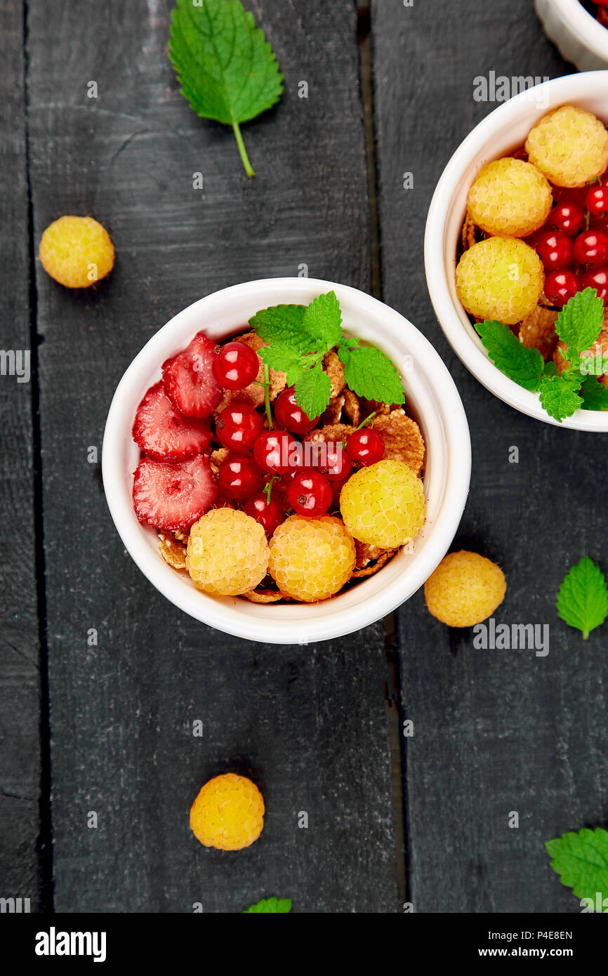 Healthy breakfast on white bowls. Fresh granola, muesli or cereal with ...