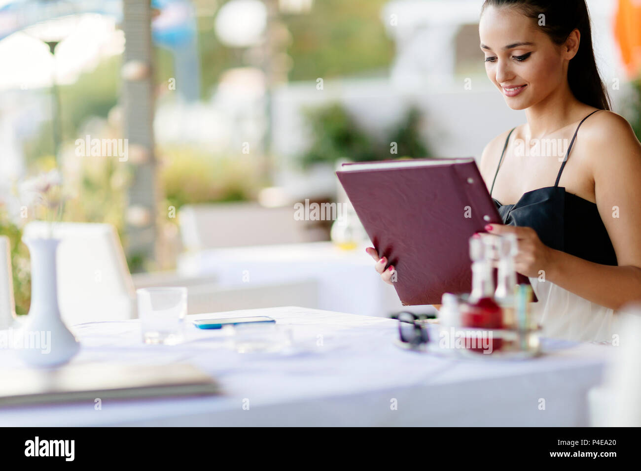 Beautiful woman ordering from menu Stock Photo - Alamy