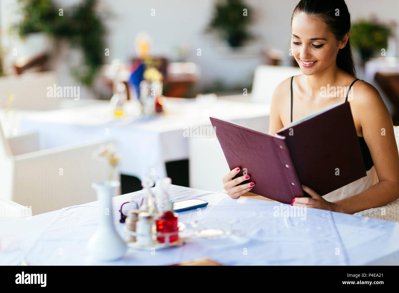 Beautiful woman ordering from menu Stock Photo - Alamy