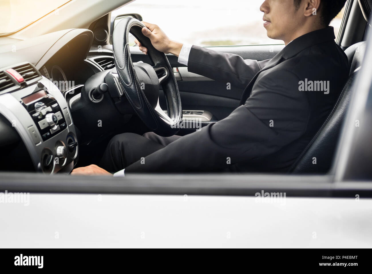 Portrait of a young handsome businessman driving a luxury sports car ...