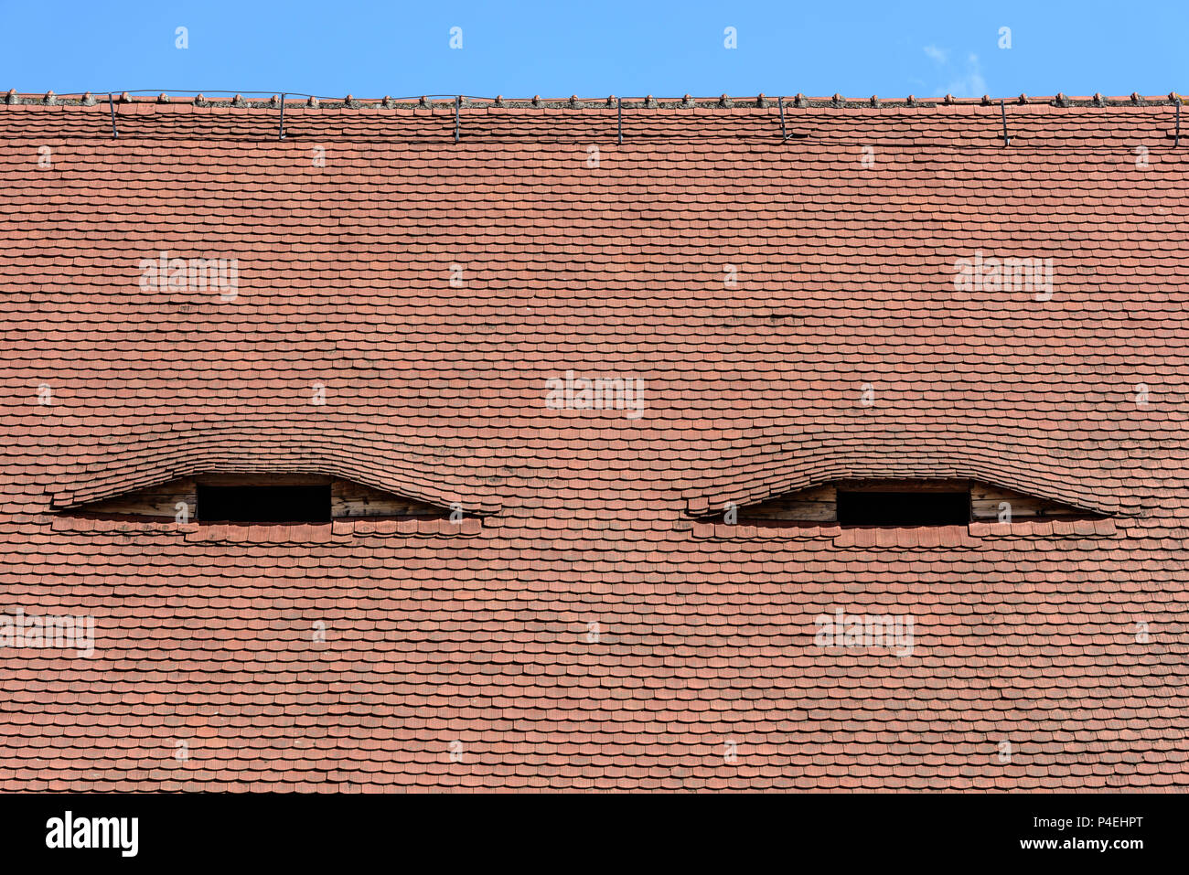 Roof with eye-like windows. Old windows at the top of the house Stock ...