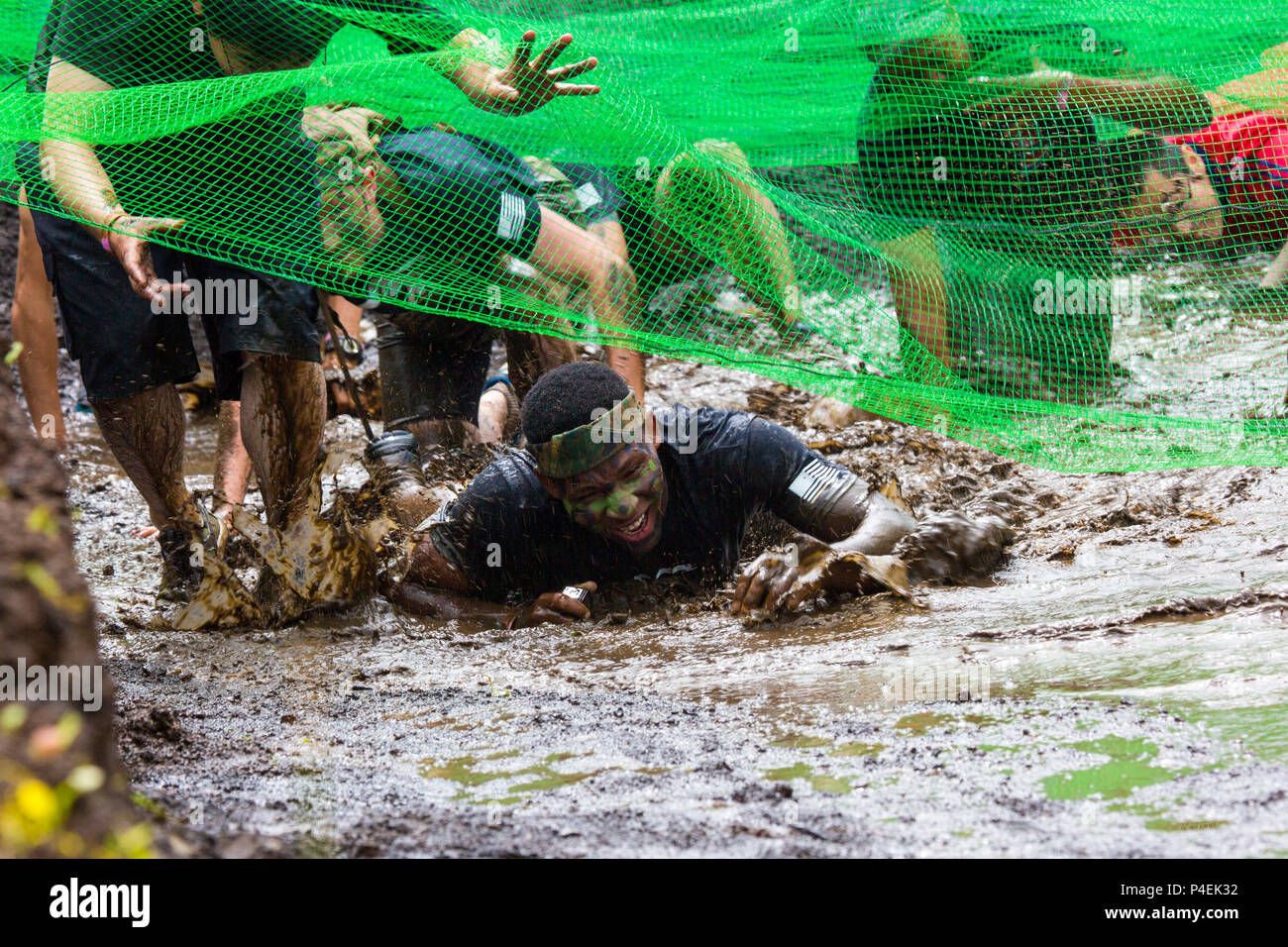 CAMP FUJI, SHIZUOKA, Japan- A participant crawls through muddy water ...