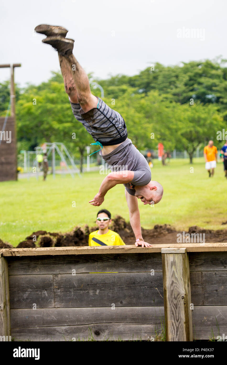 CAMP FUJI, SHIZUOKA, Japan- A participant flips over a wall during the ...