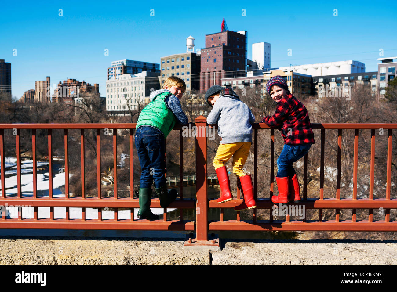Three children standing on Stone Arch bridge messing about, Minneapolis ...