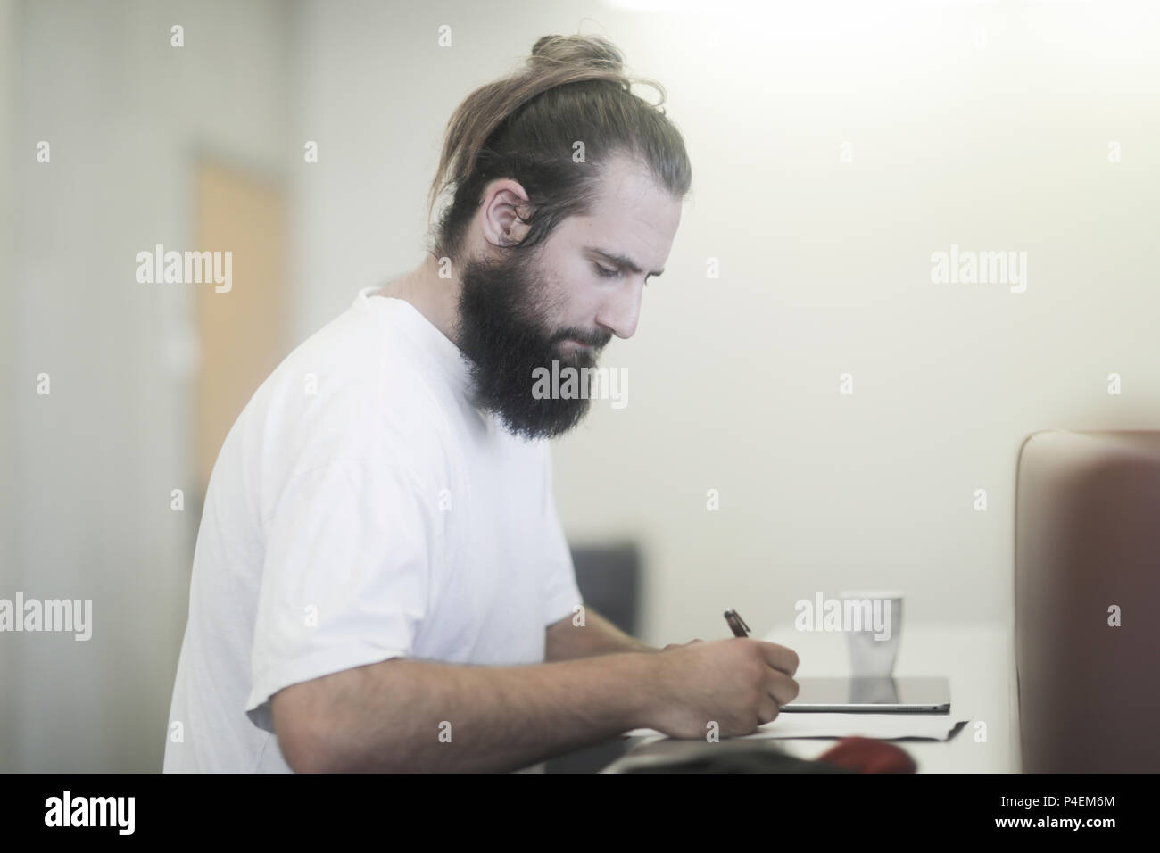 Man sitting table writing on hi-res stock photography and images - Alamy
