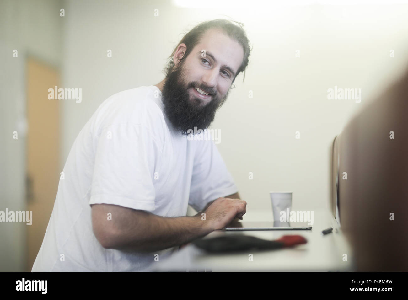 Smiling man sitting table using hi-res stock photography and images - Alamy