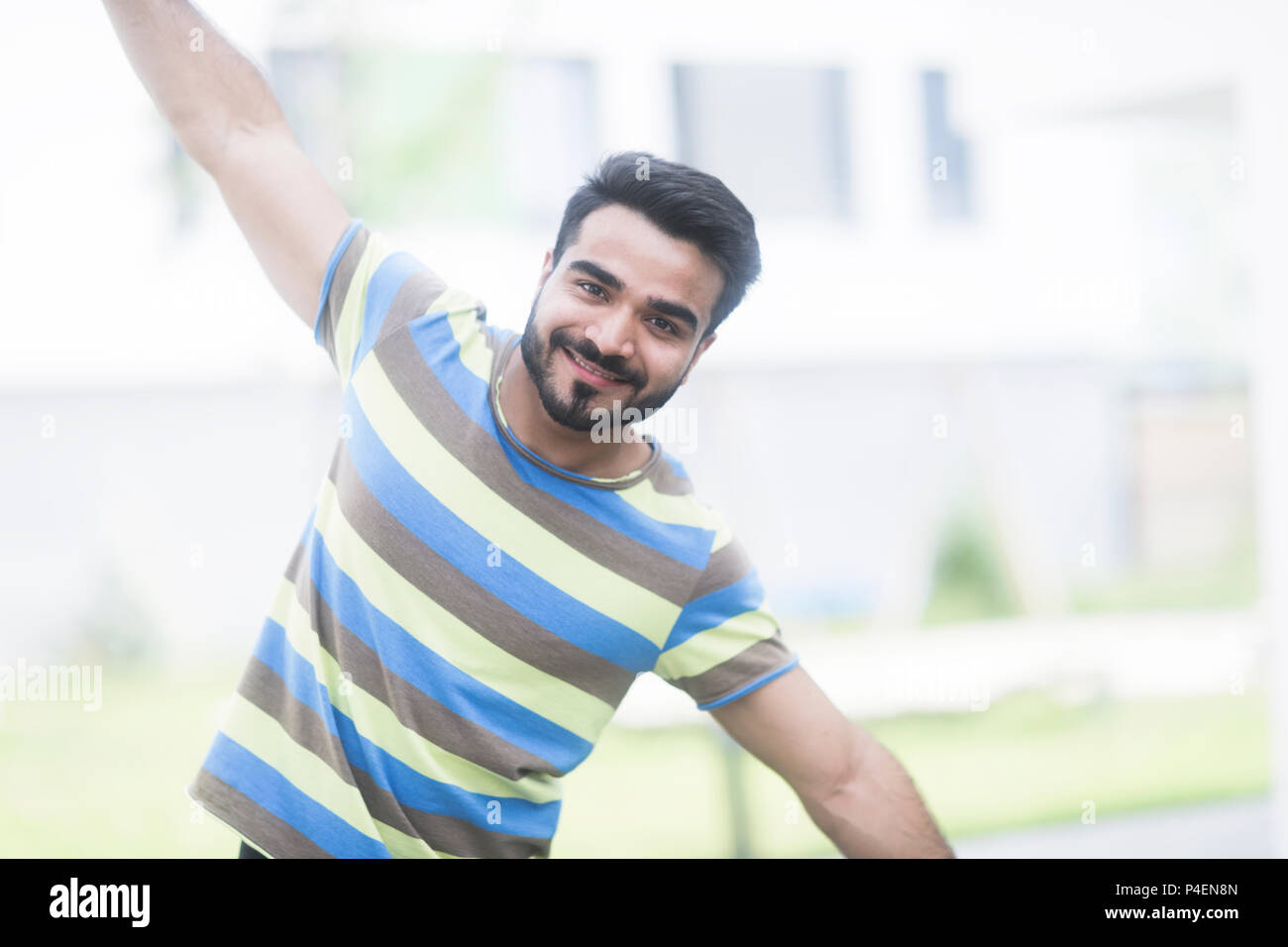 Smiling man standing outdoors with his arms outstretched Stock Photo ...