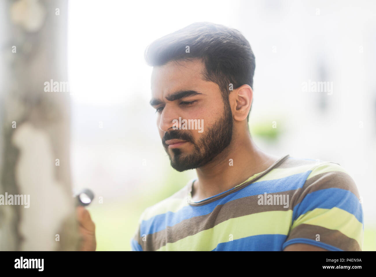 Man looking at a tree with a magnifying glass Stock Photo - Alamy