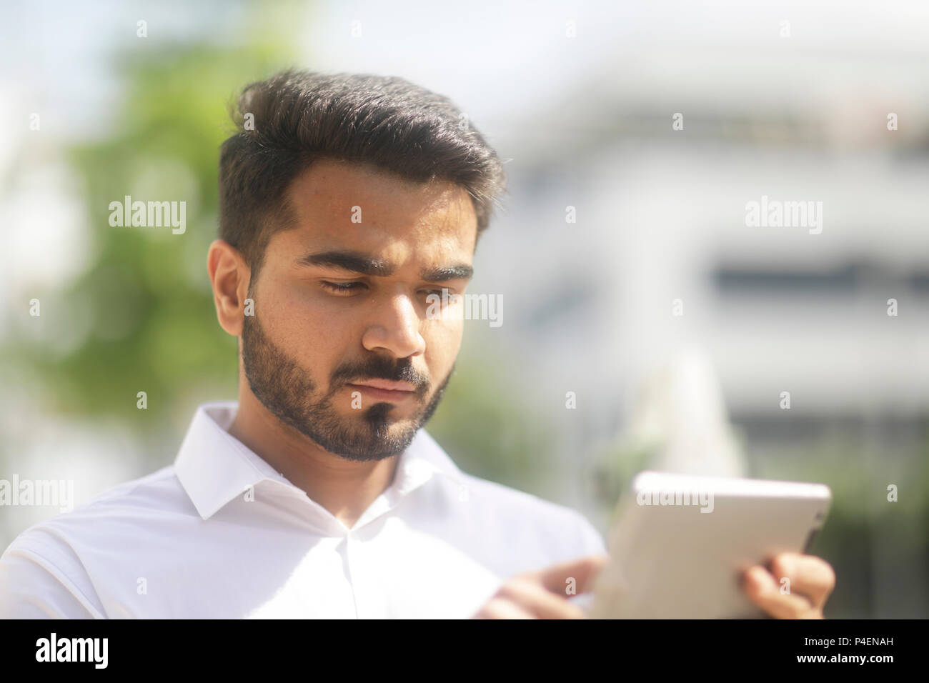 Man standing outdoors using a digital tablet Stock Photo - Alamy