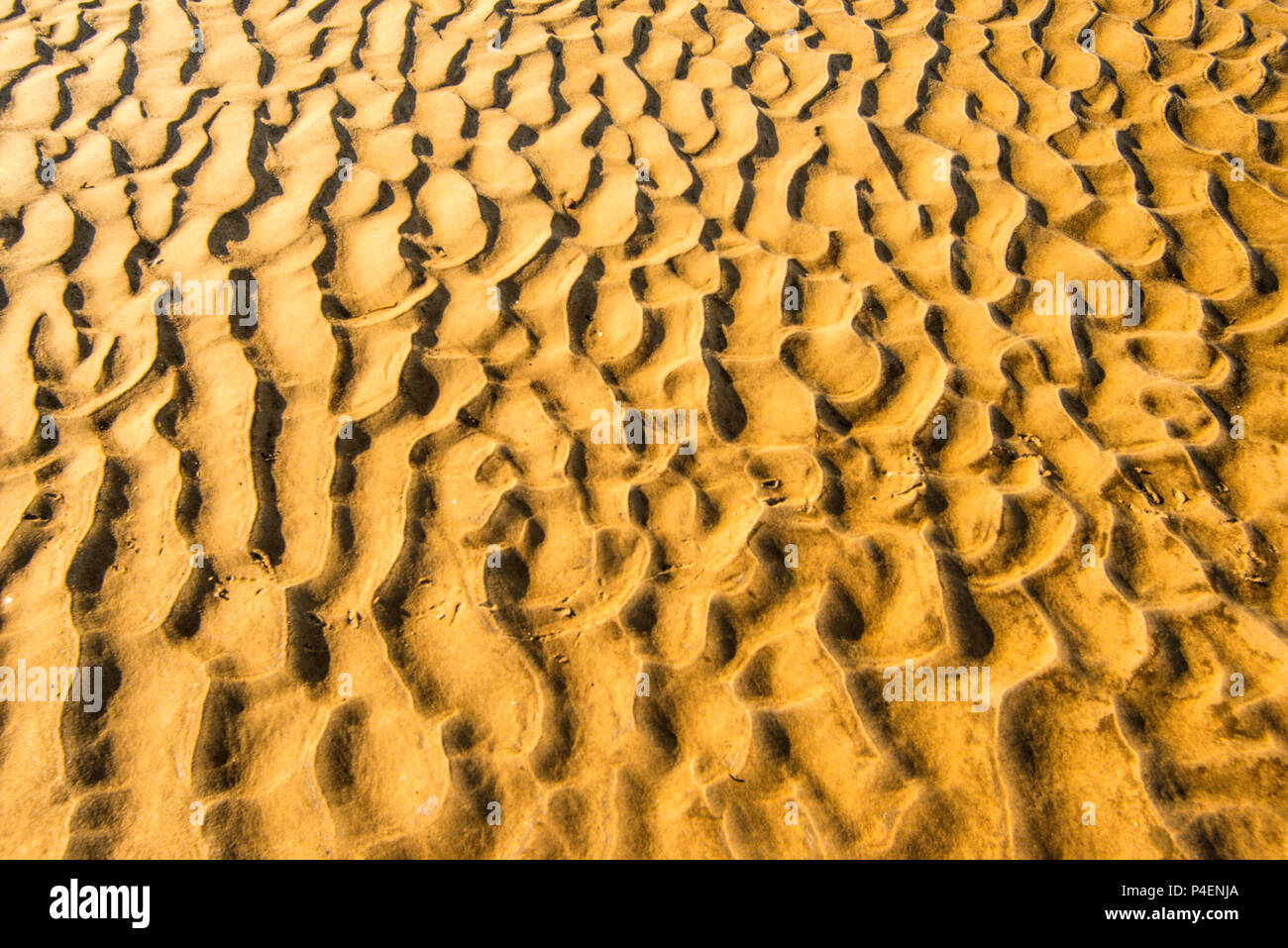 Sand of a beach with wave patterns Stock Photo - Alamy