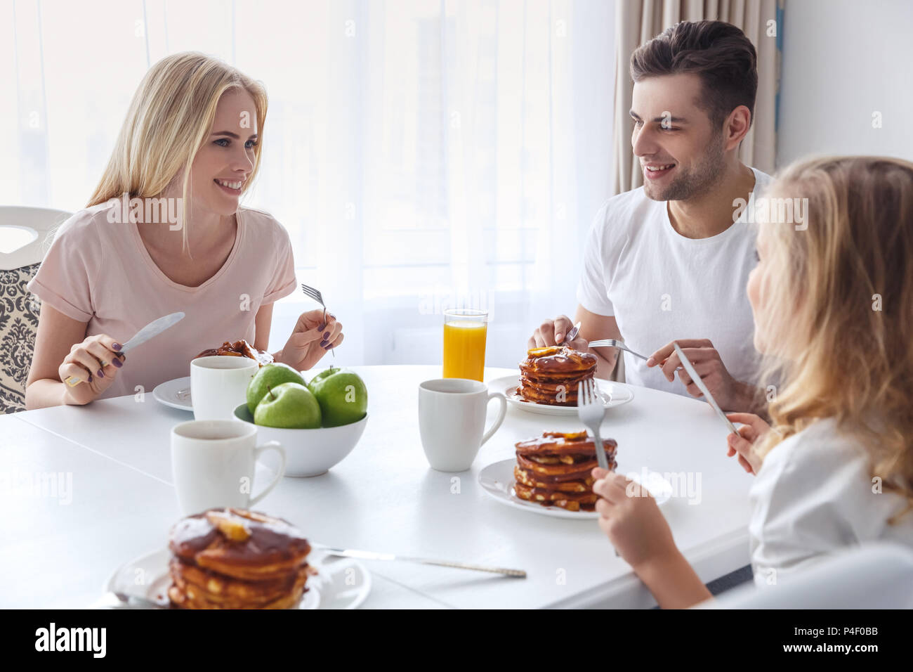 beautiful happy family eating breakfast together Stock Photo - Alamy