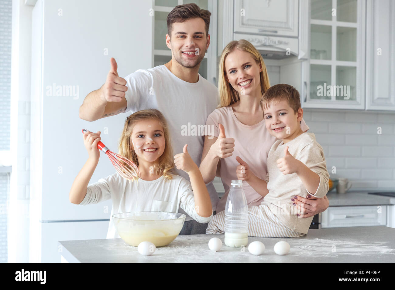 young family cooking breakfast together and showing thumbs up Stock ...