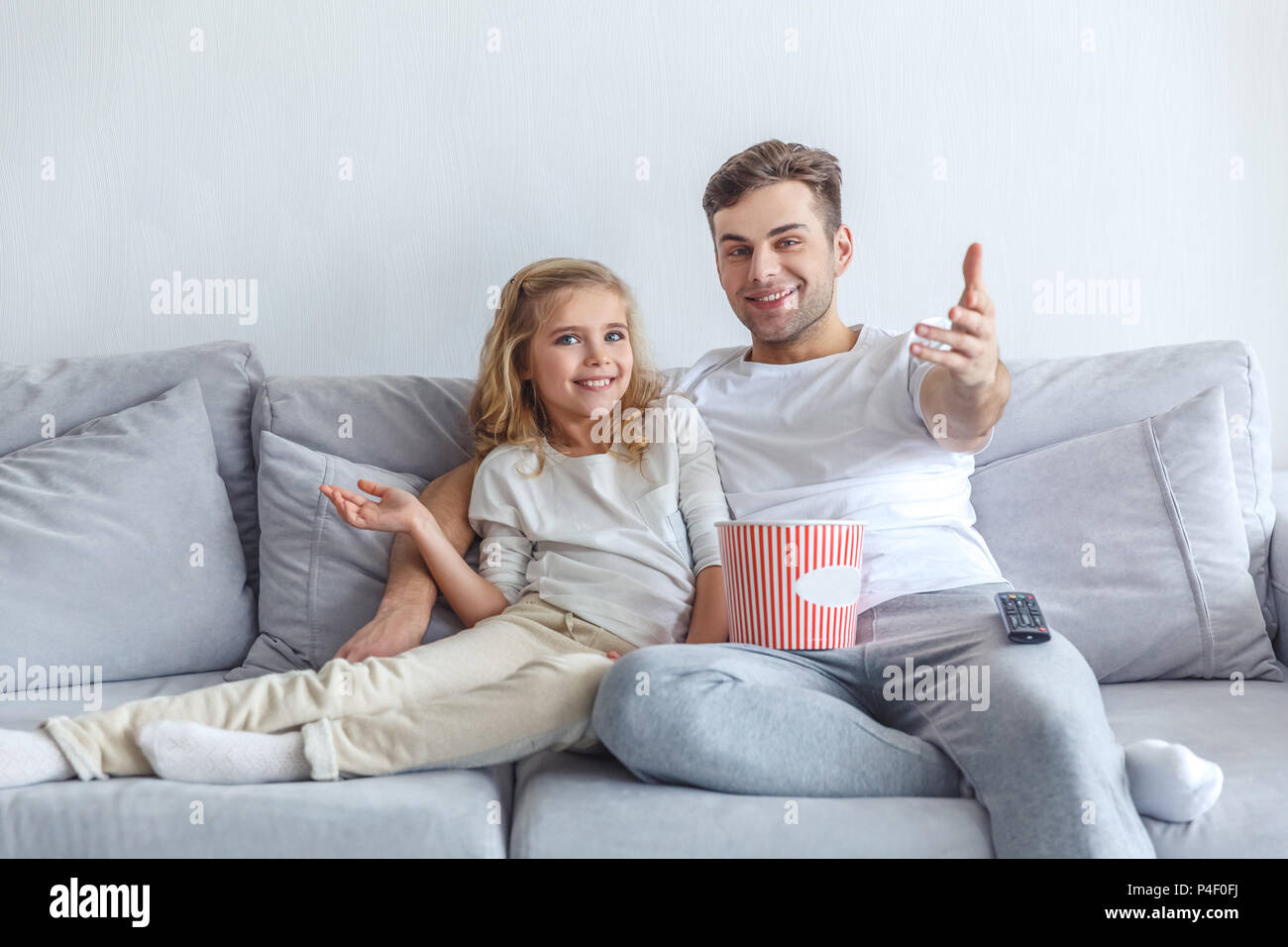 happy father and daughter watching tv together at home Stock Photo - Alamy