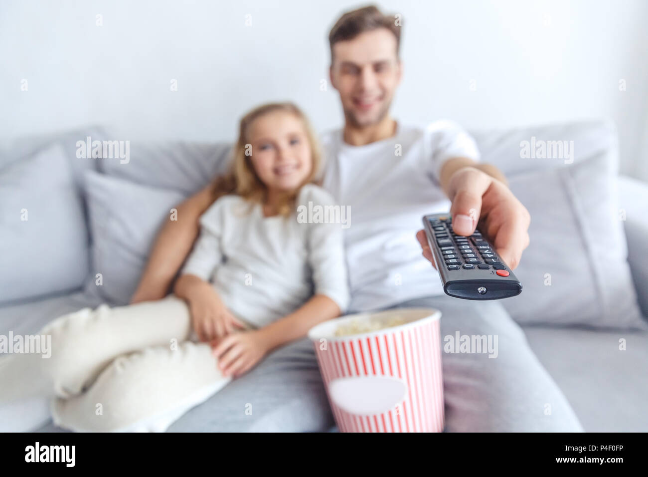 close-up shot of father and daughter using tv remote control at home ...