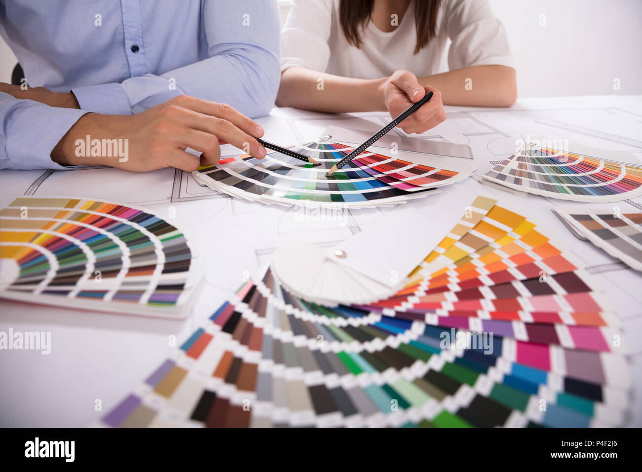 Two Architect's Hand Choosing Color From Various Colorful Swatches Over ...