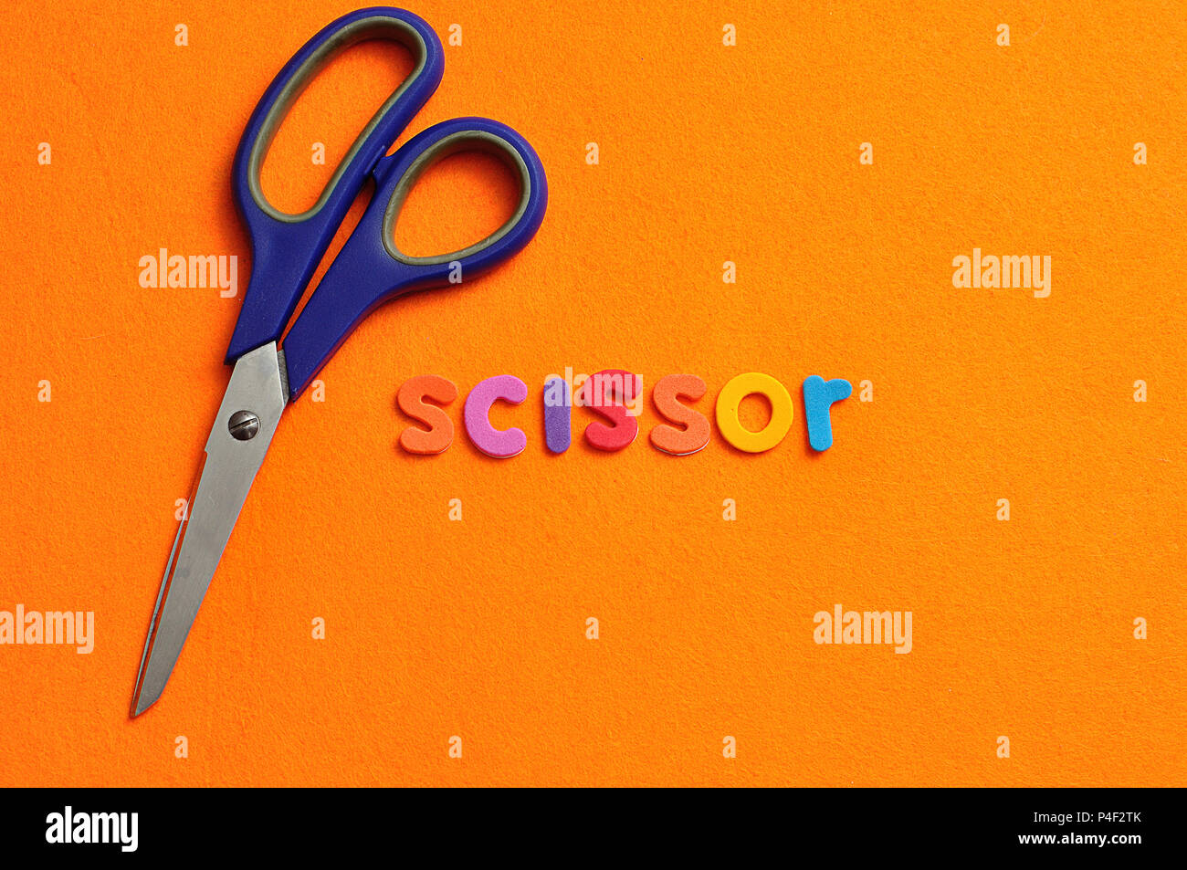 A scissor with the word scissor on an orange background Stock Photo - Alamy