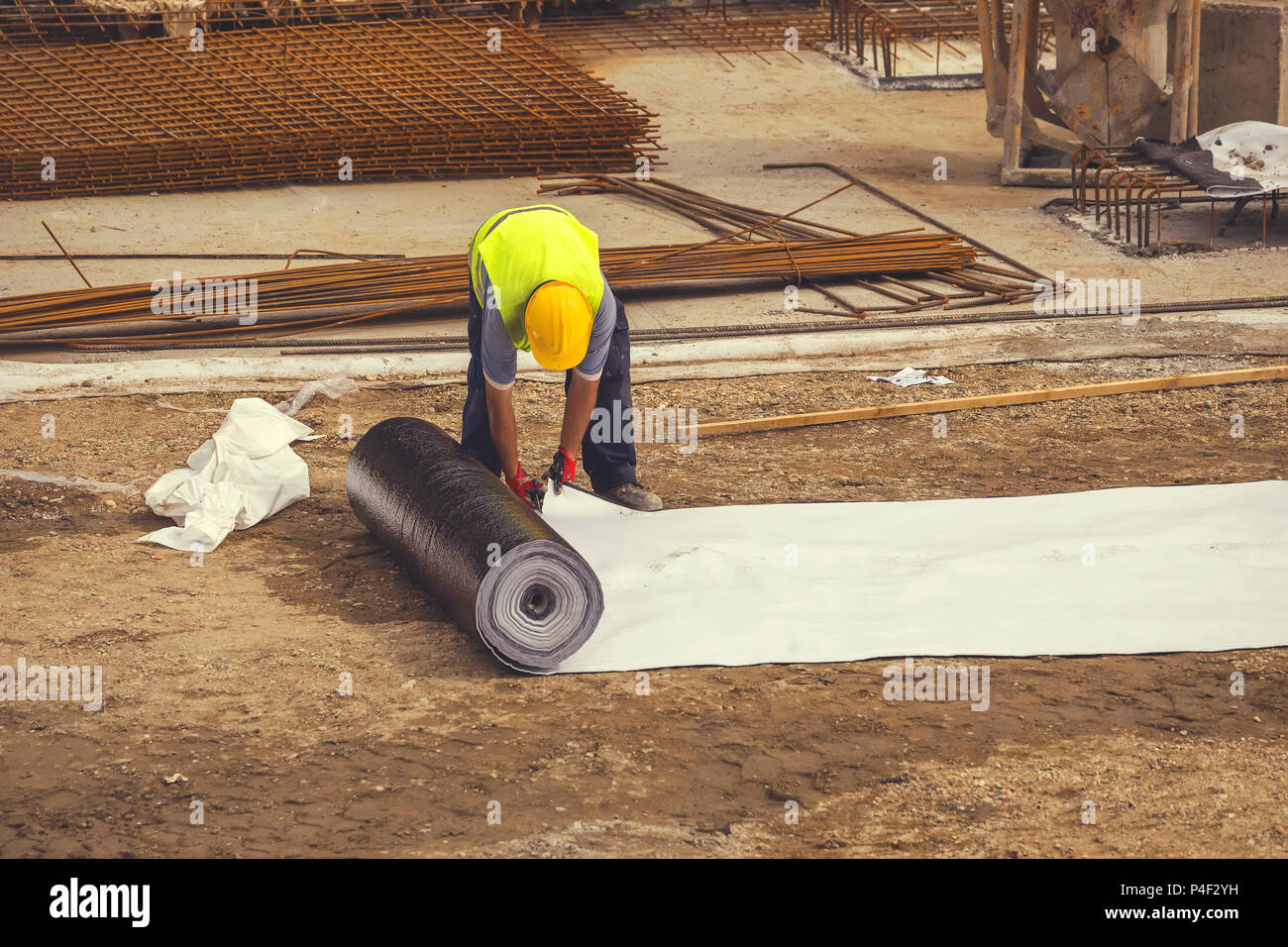 Insulation worker preparing bituminous waterproof membrane for ...
