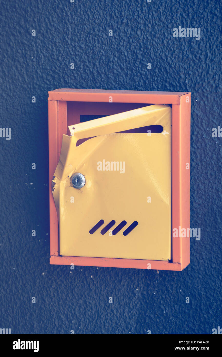 Damaged yellow mailbox hanged on a wall. Vintage style Stock Photo - Alamy