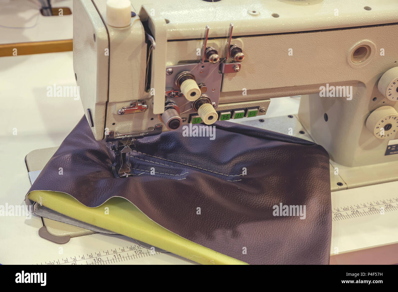 Industrial sewing machine head and item of clothing. Selective focus ...