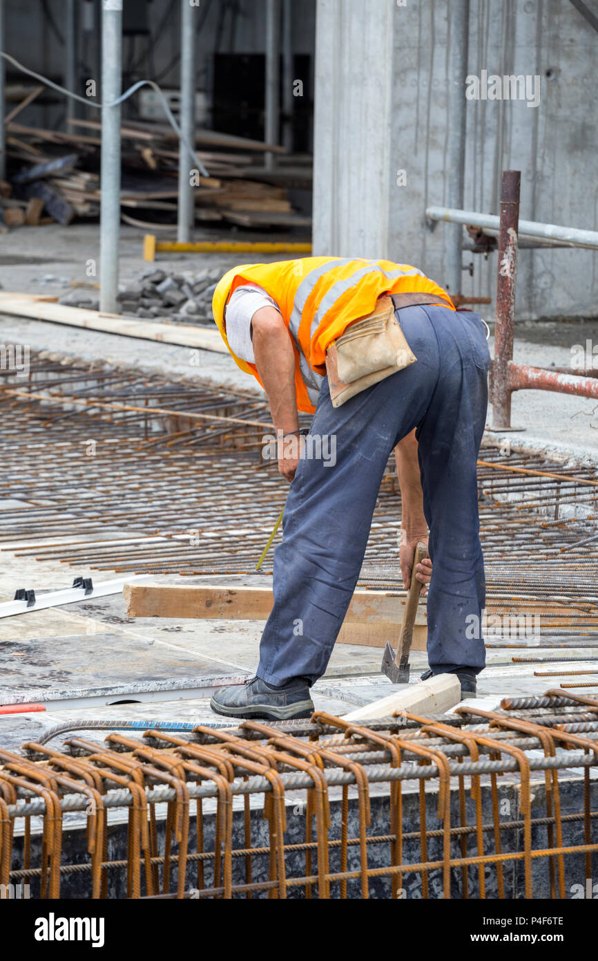 Reinforcing ironworker working on concrete formwork at construction ...