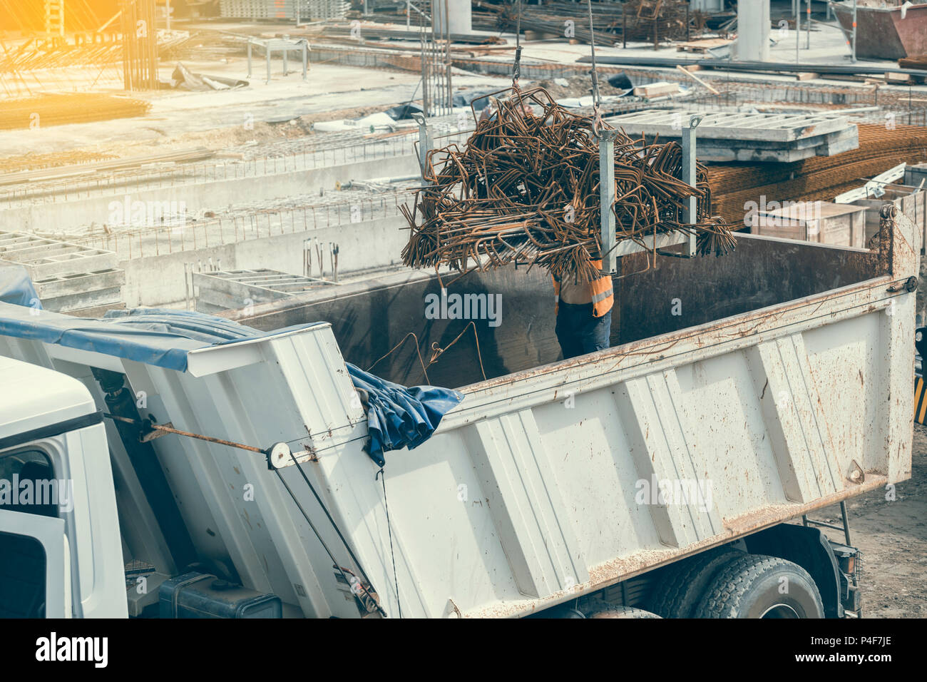 Unloading bundles of angled rebar from big truck at construction site ...