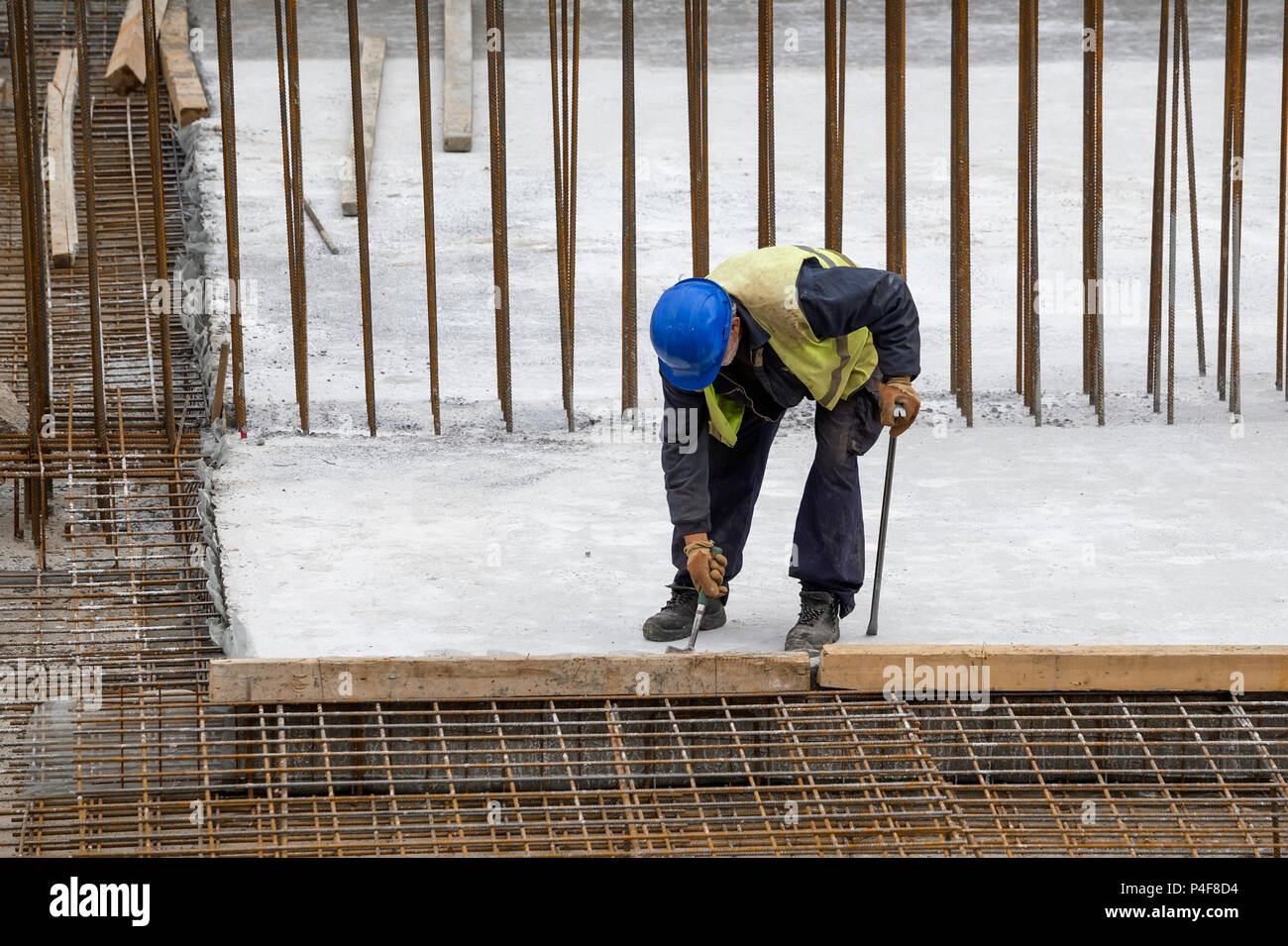 Worker with crowbar removing wooden formworks after the concrete ...