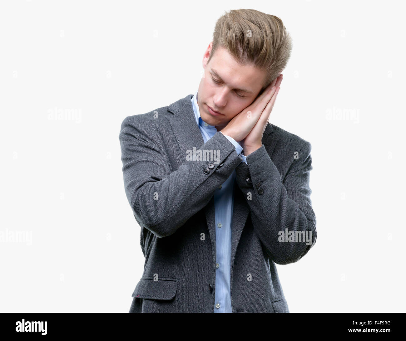 Young handsome blond business man sleeping tired dreaming and posing ...