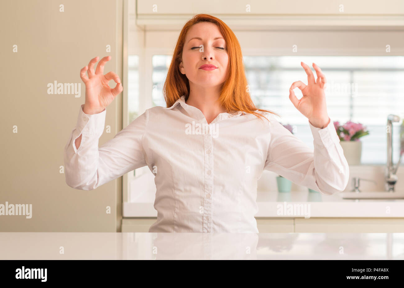 Redhead woman at kitchen relax and smiling with eyes closed doing ...