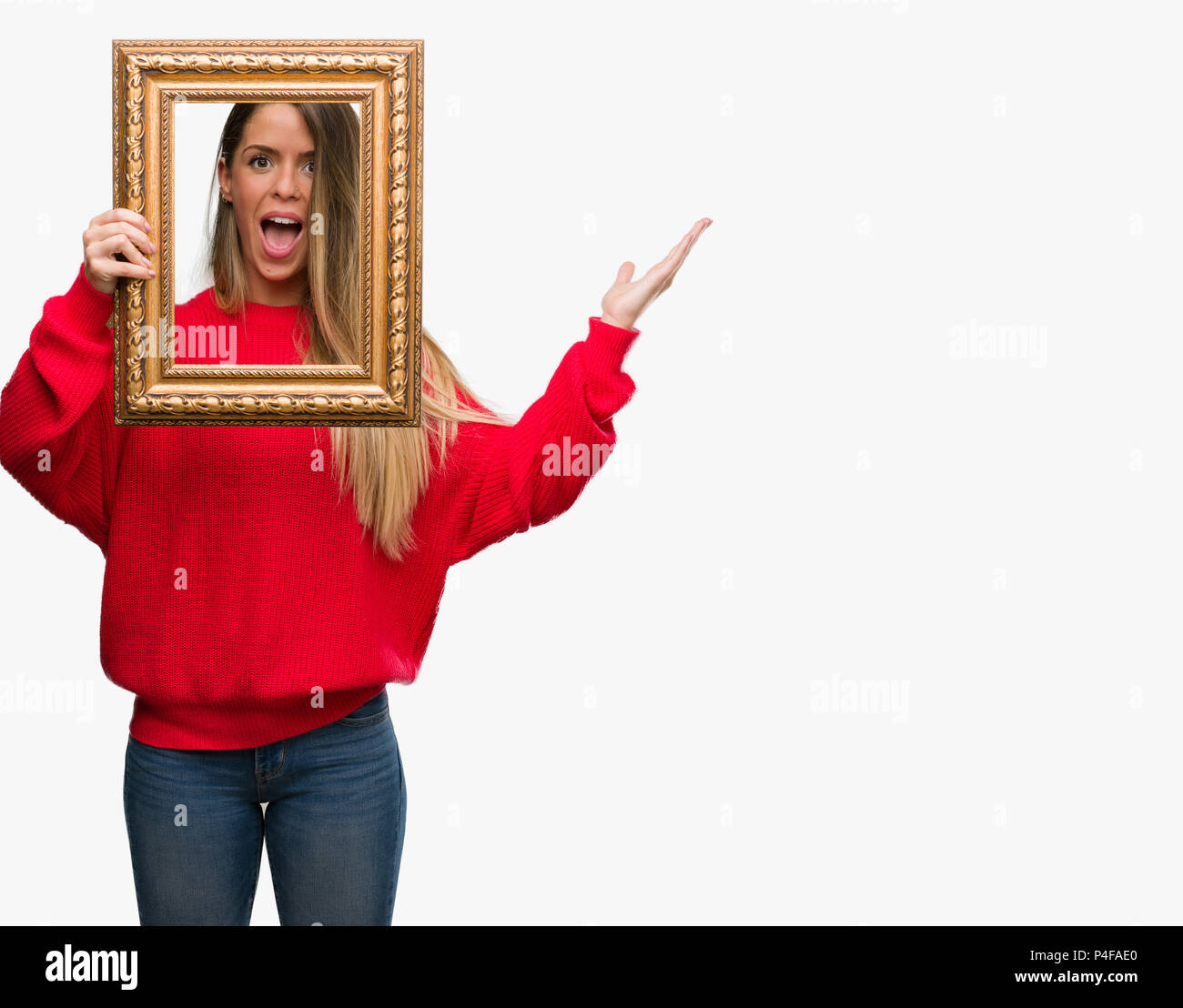 Beautiful young woman holding vintage frame very happy and excited ...