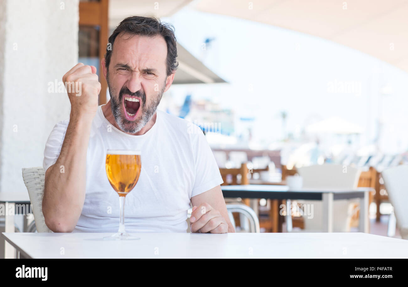Handsome senior man drinking beer at restaurant annoyed and frustrated ...