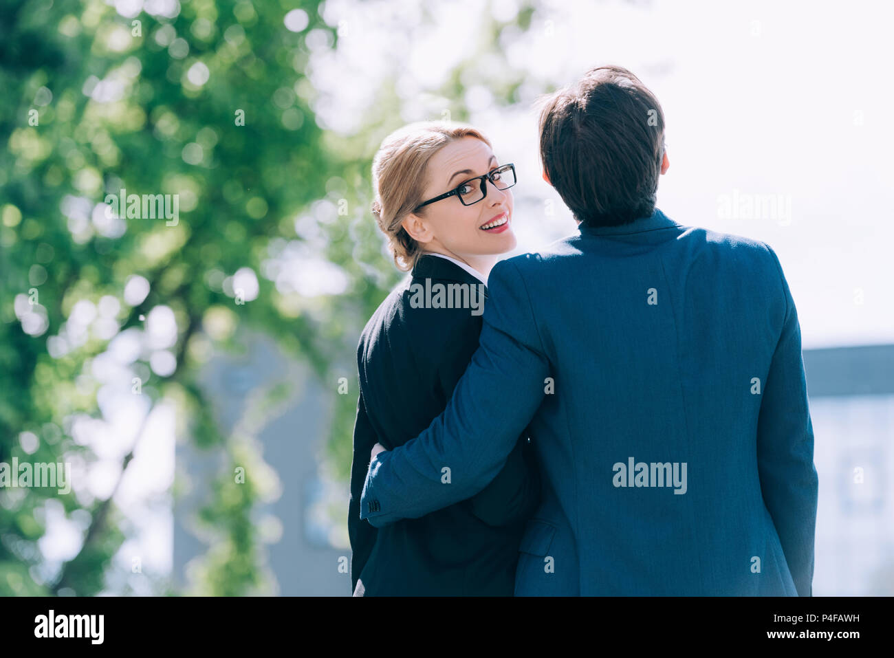 back view of middle aged business people embracing while standing ...