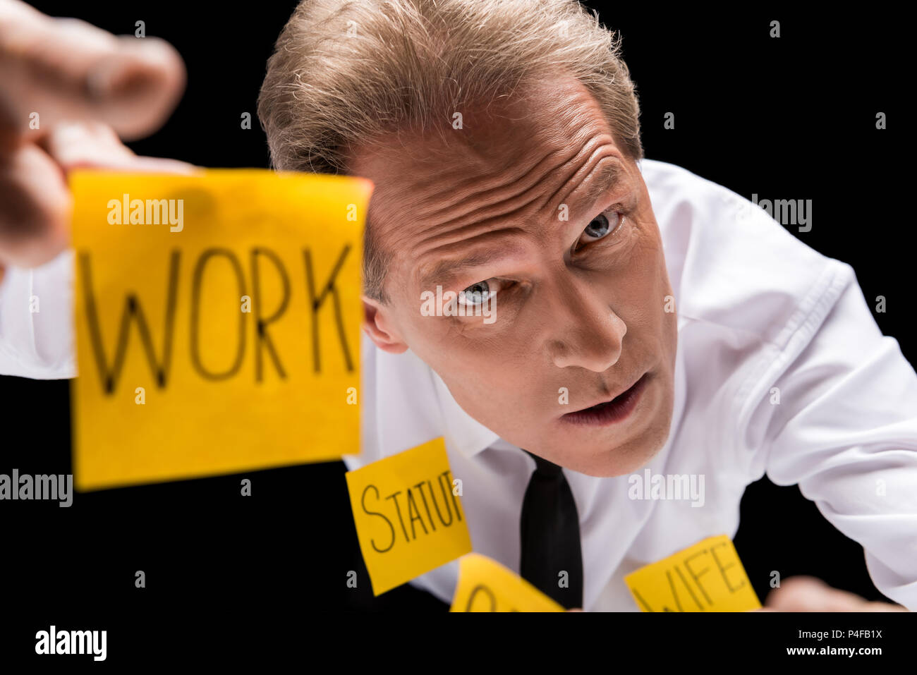 stressed middle aged businessman with sticky notes on clothes pointing ...