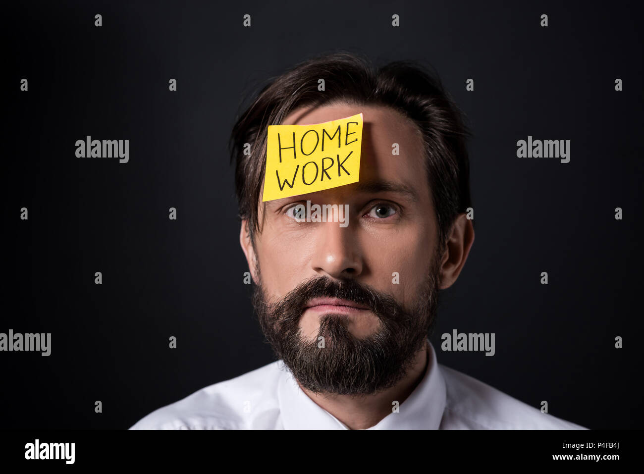 upset middle aged businessman with home work lettering on sticky note ...