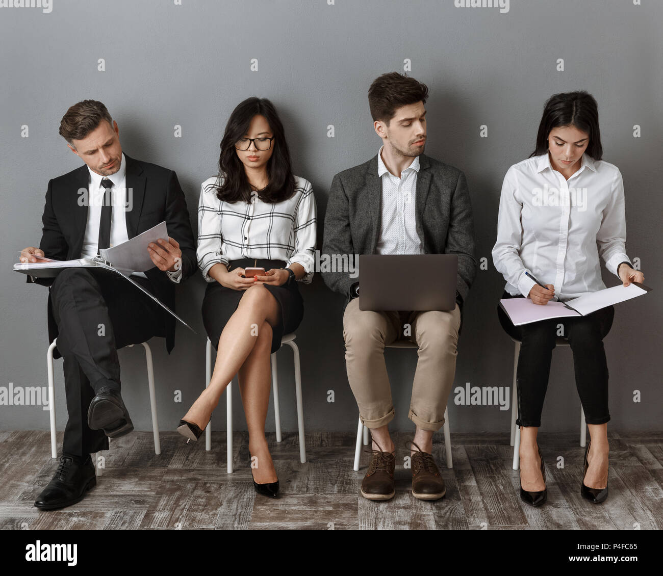 multiethnic business people with digital devices and folders waiting ...