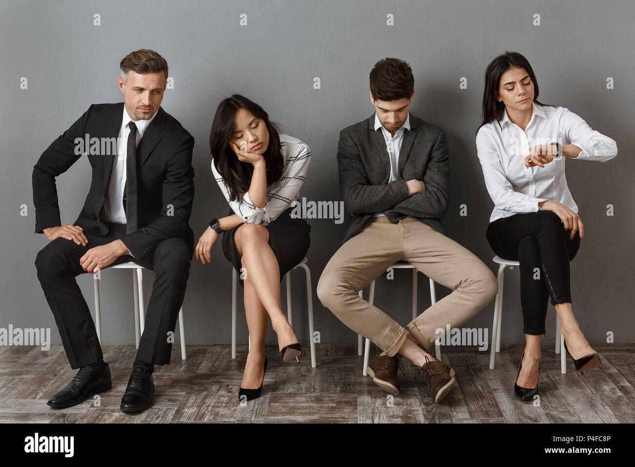 bored and tired interracial business people in formal wear waiting for ...