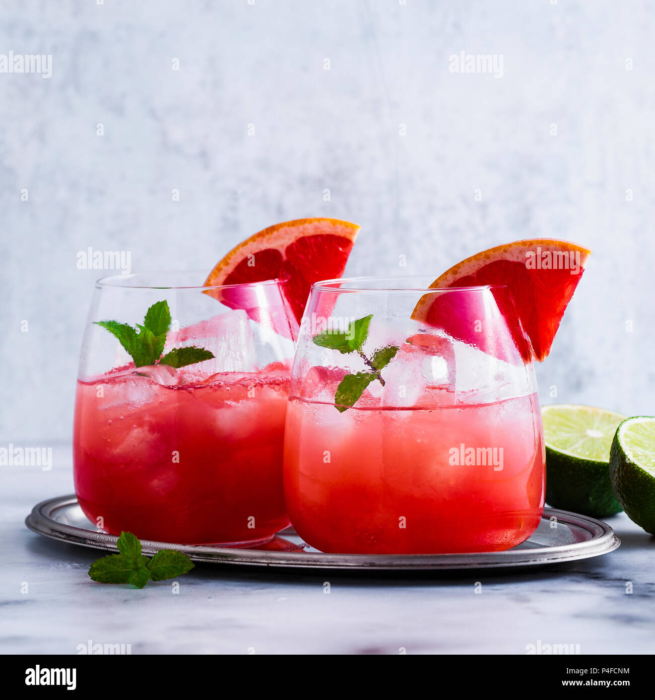 alcoholic cocktail Paloma of grapefruit and ice in glasses on a marble ...