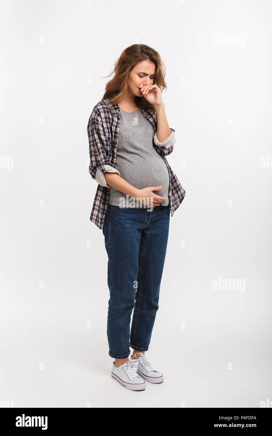 young pregnant woman touching belly and crying isolated on grey Stock ...