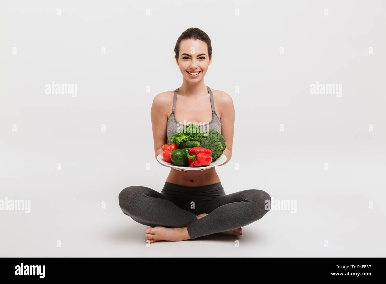 beautiful young woman sitting on floor with tray of various healthy ...
