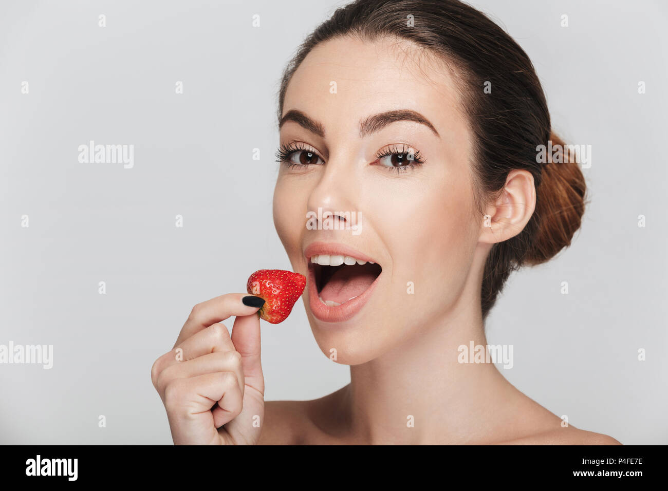 happy young woman eating strawberry isolated on white Stock Photo - Alamy