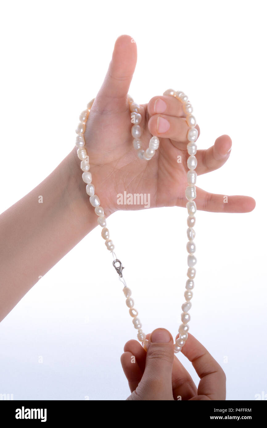 Hand holding a pearl necklace on a white background Stock Photo - Alamy