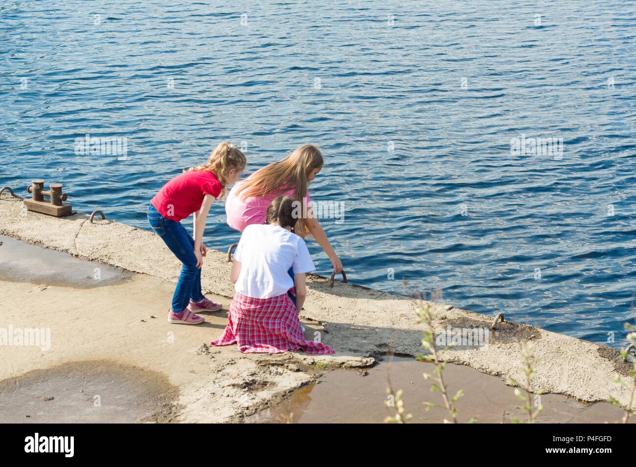 Children play near the river on the city embankment. View from above ...