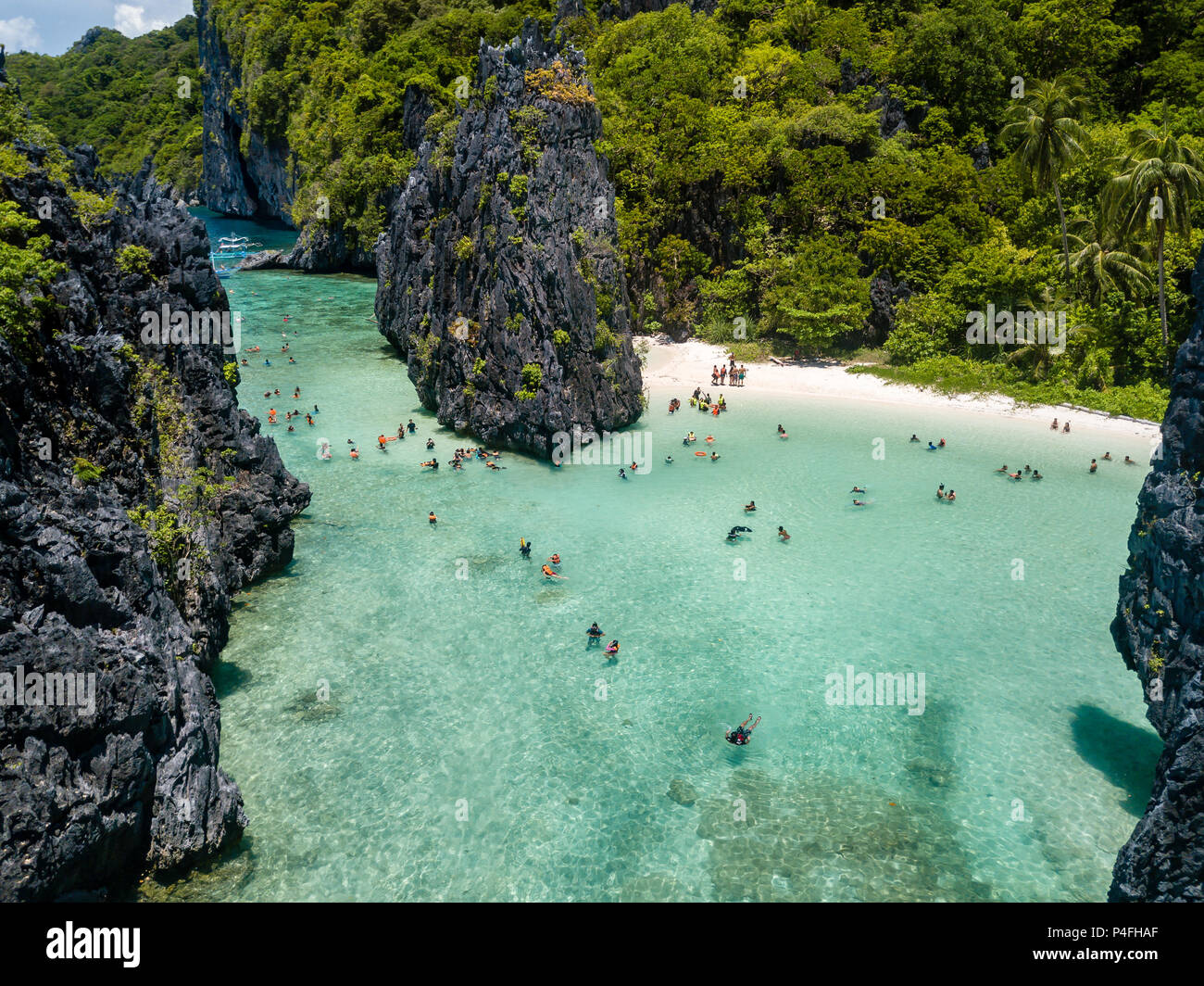 Aerial drone view of swimmers and tourists inside a beautiful, shallow ...