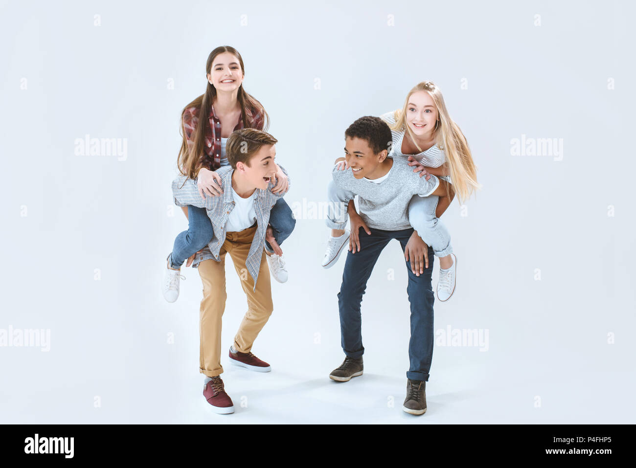 happy multicultural boys and girls piggybacking together isolated on ...