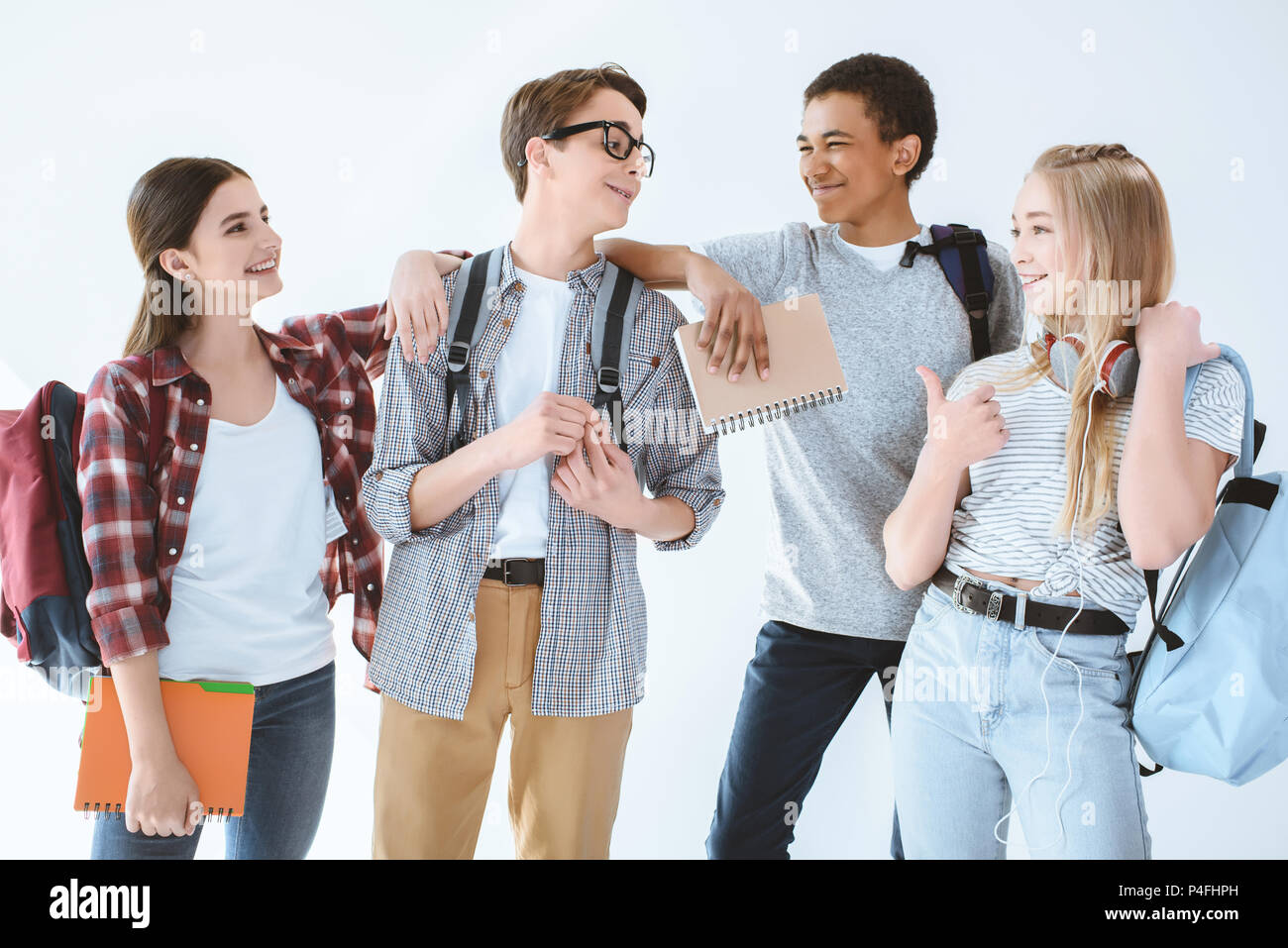 multiethnic students with backpacks having conversation together ...