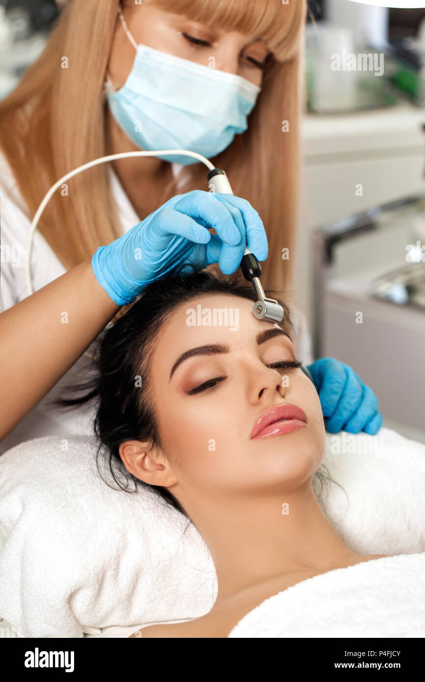 Beautician makes cleaning of face in spa salon Stock Photo - Alamy
