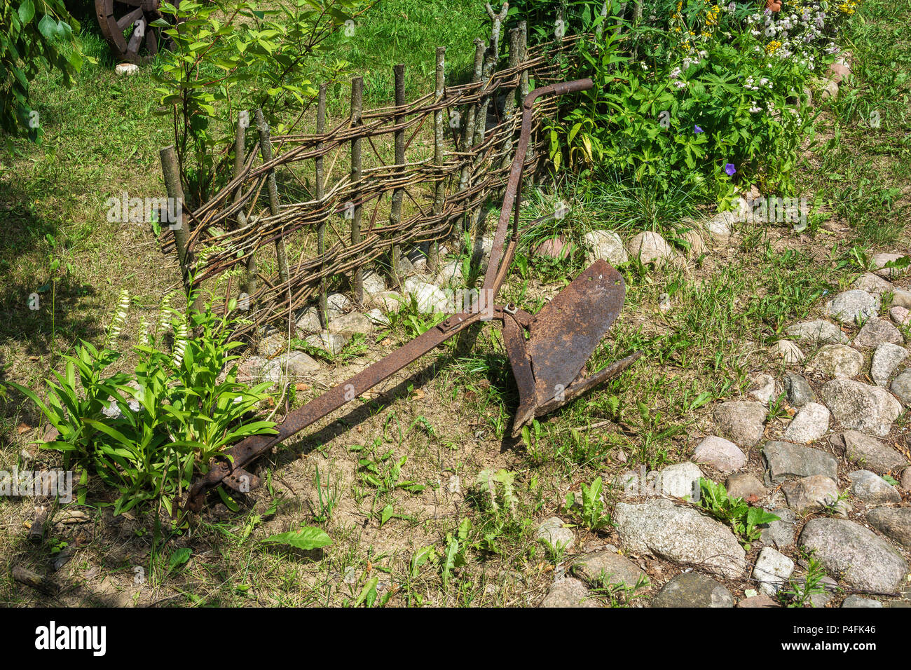Old rusty metal plow lying on the grass near the fence Stock Photo - Alamy