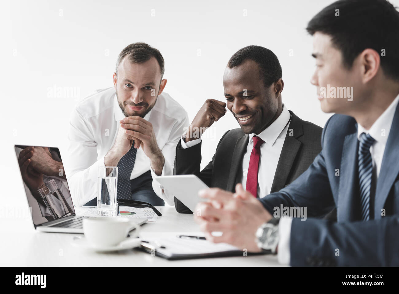 multiethnic businessmen having discussion during meeting at workplace ...